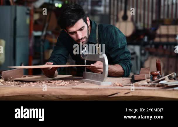 Luthier making wooden musical and using traditional tools in workroom ...