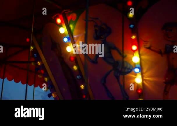 A vibrant amusement ride adorned with glowing lights against the night ...