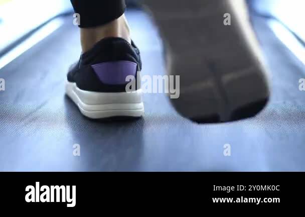 Treadmill in the gym. Back view of legs in sneakers walking on the ...