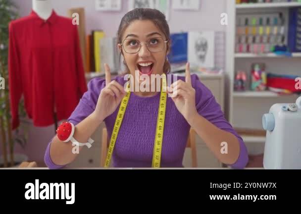Look of surprise! young, vibrant hispanic woman dressmaker, sitting at ...