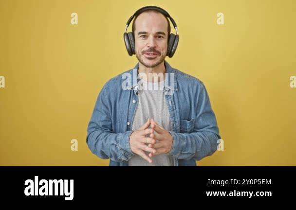 Bald hispanic man with beard wearing headphones and denim jacket ...