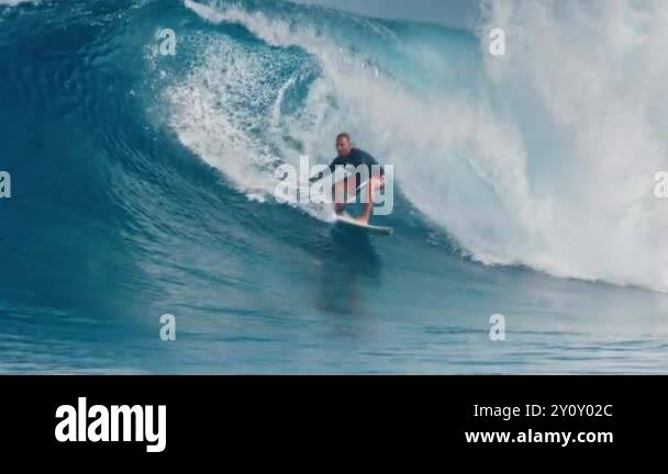 Experienced surfer rides huge, double overhead ocean wave at the famous ...