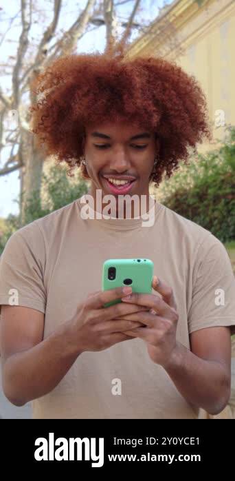 Vertical One african american teenager using a cellphone to send funny ...