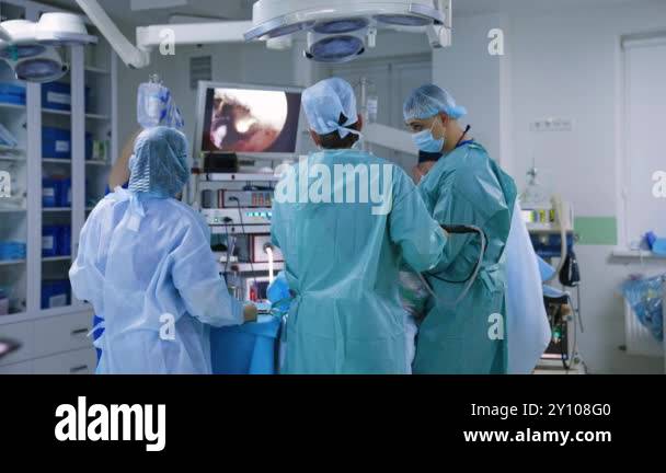 Medical team stand around the operational table. Medics look at the ...