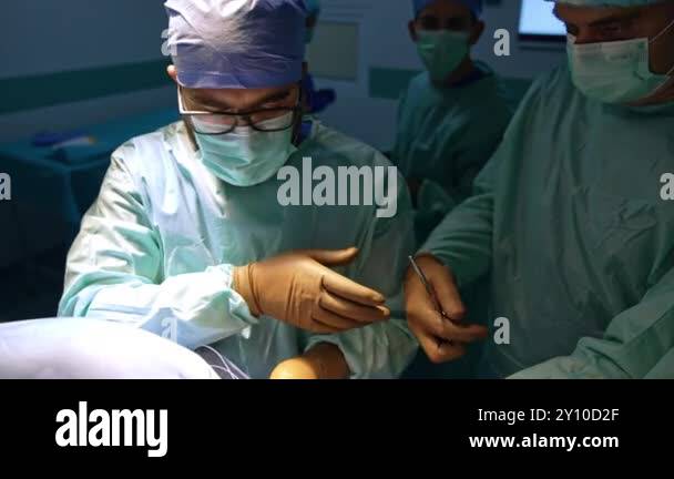 Doctor holds his hand up waiting for the instrument. Assisting staff ...
