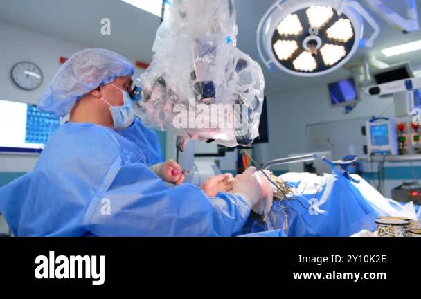 Caucasian surgeon wearing blue uniform, mask and cap looks at ...