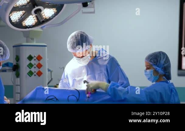 Medical team working in the modern surgery room. Male neurosurgeon in ...