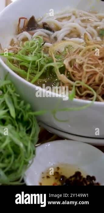 Vietnamese soup pho girls hand takes rice noodles with chopsticks eat ...