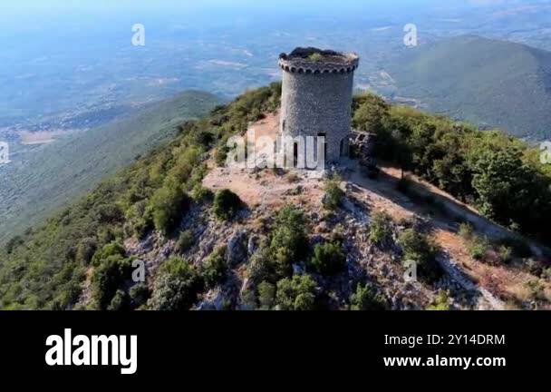 Camera is rotating around an old stone tower built on top of a mountain ...
