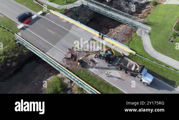 Road construction. Workers repairing destroyed bridge after hurricane ...