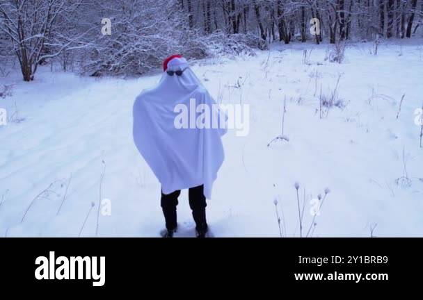 Man dancing wearing ghost costume with sunglasses and Santas hat in ...