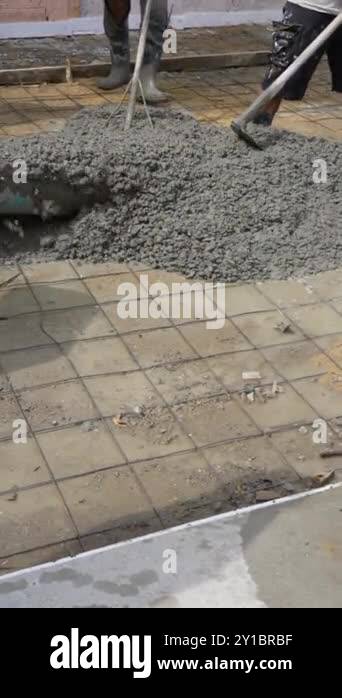 Vertical Footage of Workers Using Shovel and Rake to to Place Concrete ...