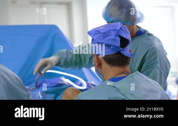 Surgeon takes a metal orthopedic tool from the scrub nurse. Process of ...
