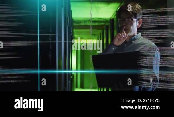 Working on laptop, man in server room with coding animation over green ...