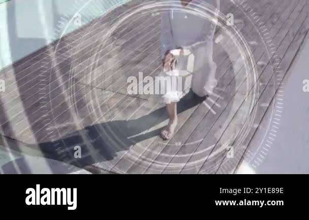 Circular digital interface animation over woman sitting on wooden deck ...
