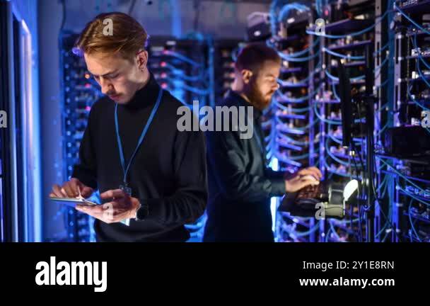 Two men programming in a server room Stock Video Footage - Alamy