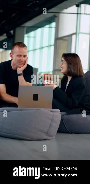 Emotional communication of two colleagues at work. Man and woman sit in ...