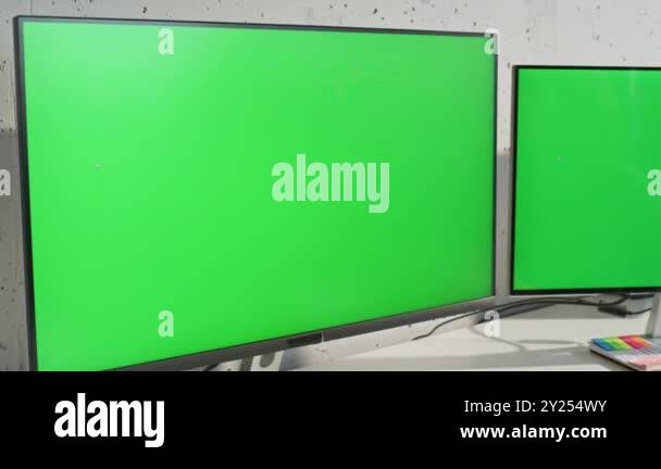 Two chroma key displays standing at light office table zoom out ...