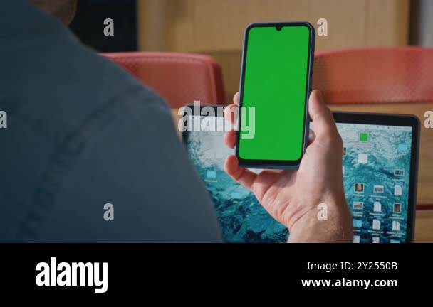 Man finger tapping mockup cellphone at home laptop workplace closeup ...