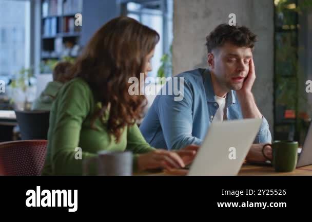 Office manager helping colleague doing work task sitting together at ...