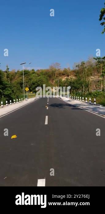 Motorcyclists pass through smooth and quiet asphalt roads in the ...