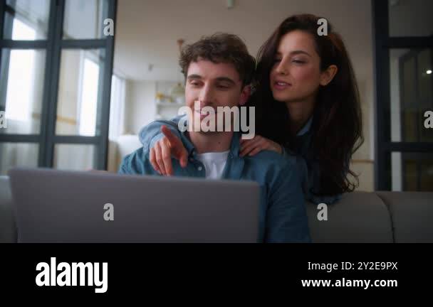 Caucasian woman female girl wife girlfriend hugging man back discuss shopping computer talk ...