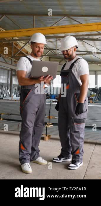 Two diverse workers with laptop in warehouse metal profile. The concept ...