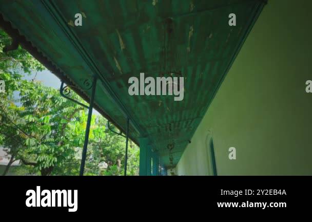 A view of a green, weathered ceiling with hanging lights, surrounded by ...