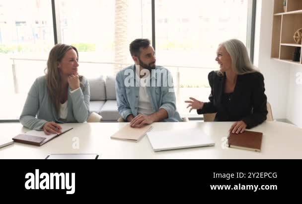 Elder business coach training employees, talking to younger colleagues ...