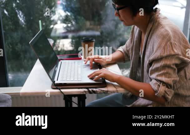 Distance learning online education and work Asian woman working office work remotely from cafe ...
