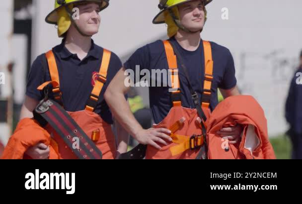 A group of prepared firefighters stands ready for hazardous tasks ...
