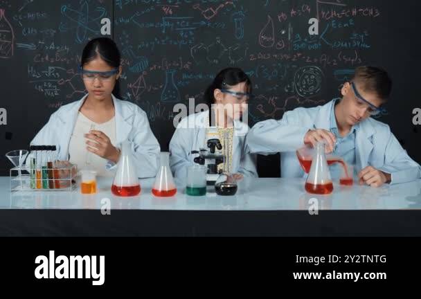 Professional diverse student doing experience at blackboard with chemical theory in STEM science ...