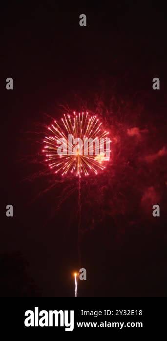 A dynamic display of vibrant red fireworks explodes and shifts colors ...