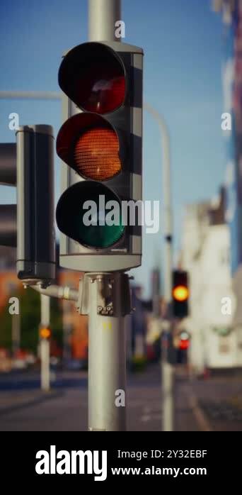 A close-up shot captures a traffic light with a red light at the top, a ...