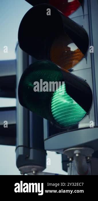 A close-up view showcases a modern traffic light with a shiny metallic ...