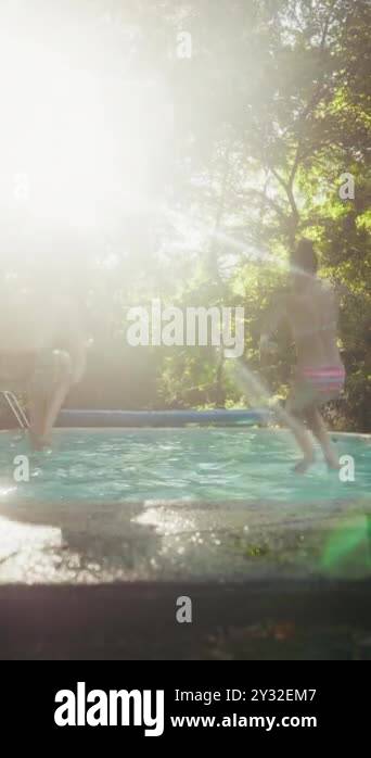 Two kids jump into the pool with cannonball-style leaps, creating big ...