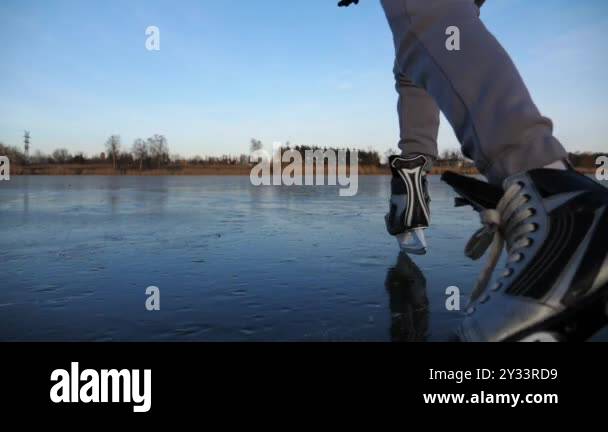 Young man in figure skates sliding fast on ice surface during training ...