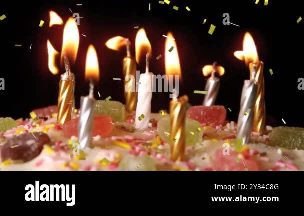 Burning candles on birthday cake with colorful candies with gold ...