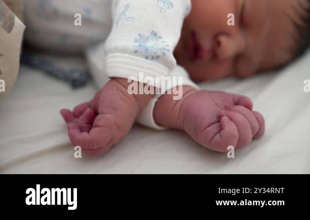 Close-up of a newborn baby's tiny hands as the infant sleeps peacefully ...