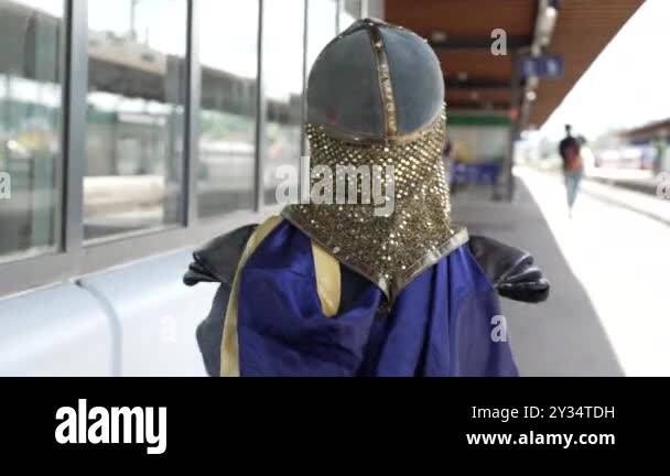 Child in knight costume walking forward on a train platform ...
