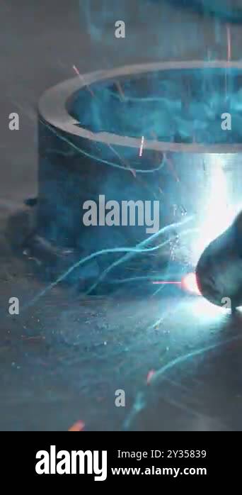 Close-up welding with sparks and metal ring. Creative. Welder welds ...