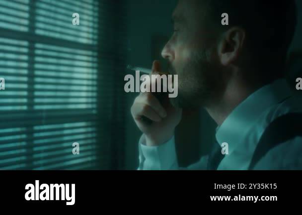 Thoughtful detective standing in dark room at crime scene, looking ...