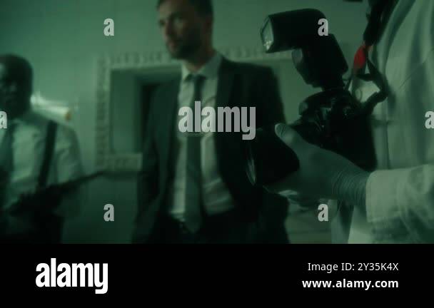 Close up view of forensic photographer in white coat and gloves holding ...