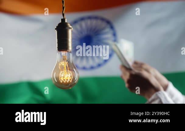 Glowing Edison light bulb on Indian flag background. Woman counting ...