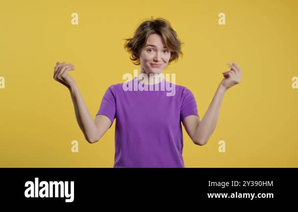 30s woman with money gesture on yellow studio background. Smart lady ...