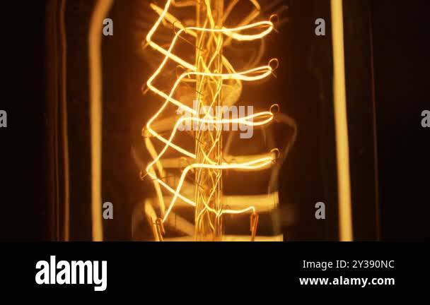 Bright glowing Edison Tungsten lamp on dark night, black background ...