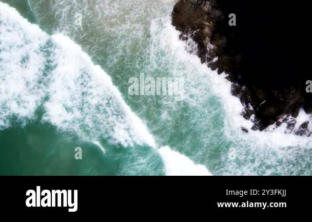 From a drone's perspective, the majestic sea waves roll in, gracefully ...