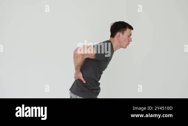 Ill man holds hands on bent back feeling acute pain on white background ...