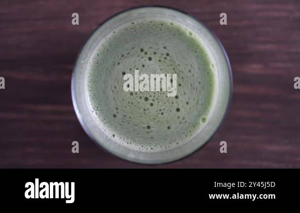 Glass of green smoothie, rotates, close up, top view. Healthy organic ...