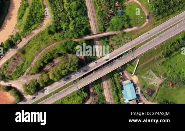 During sunrise in Malaysia, an aerial view of a road flyover crosses ...